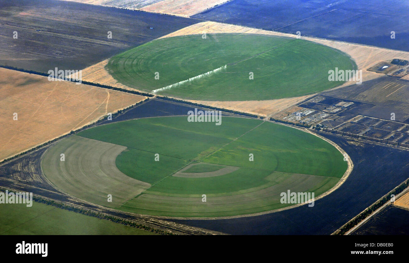 The aerial picture taken from an aircraft shows round and square fields ...