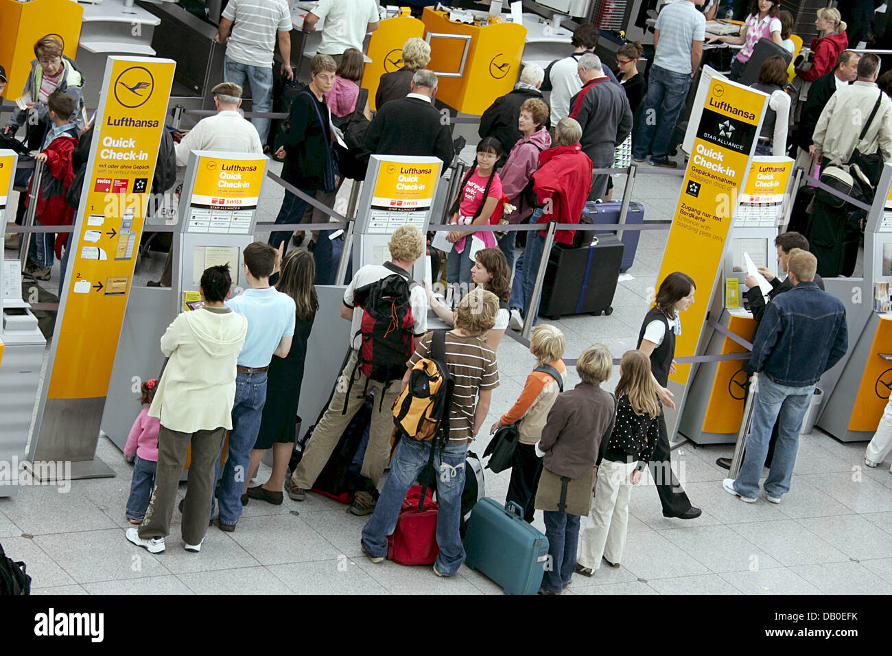 Passengers queue in front of the Lufthansa check-in counters at the ...