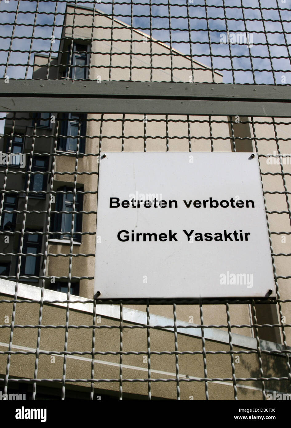 A sign attached to the fence of the women's prison reads in both German ...