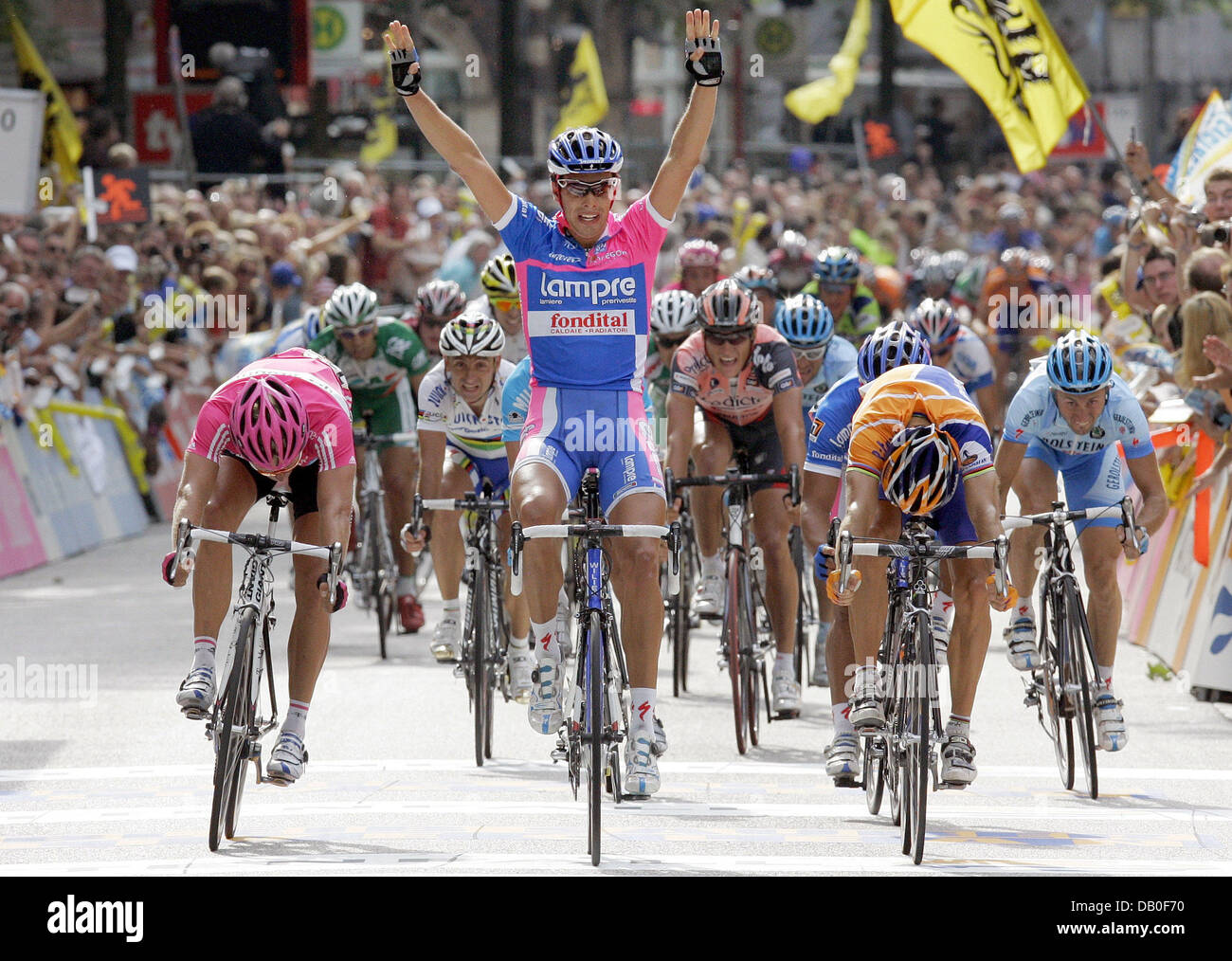 Italian cyclist Alessandro Ballan (C) raises his arms as he crosses the ...