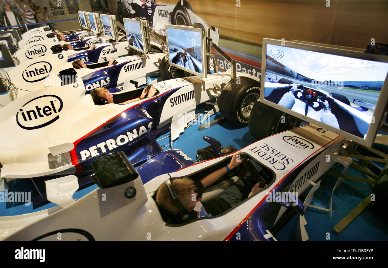 Young visitors play a driving simulator game at the 'intel' booth of ...