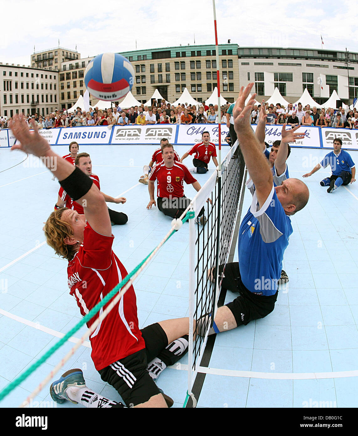 The photo shows players in action during the seated volleyball match ...