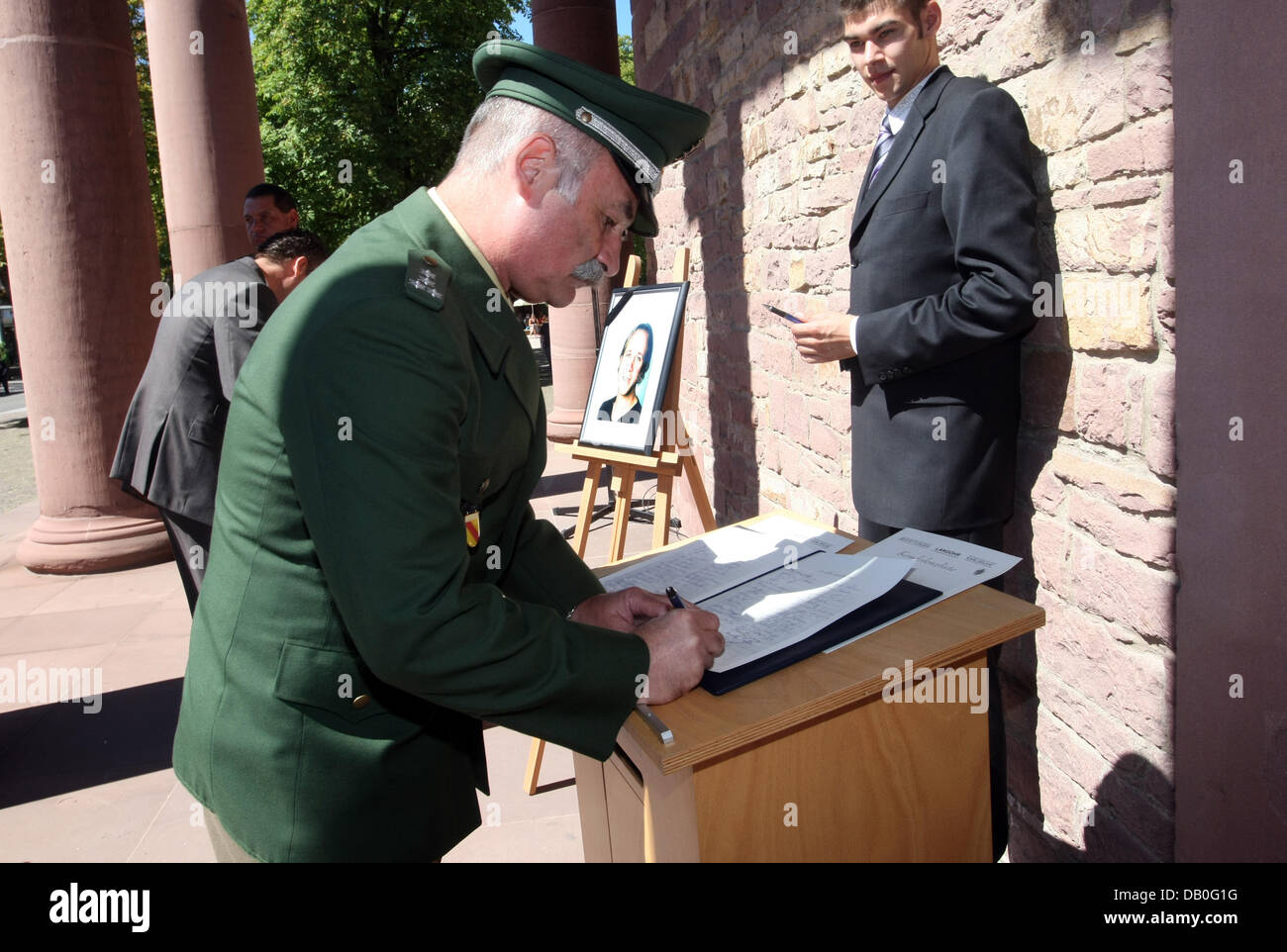 A police officer signs a condolence book ahead of the oecumenic funeral ...