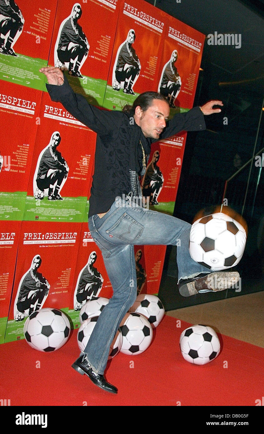 Actor John Friedmann poses with footballs as he arrives for the ...
