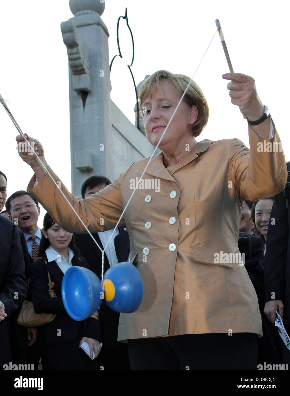 German Chancellor Angela Merkel dabbles at playing diabolo during a ...