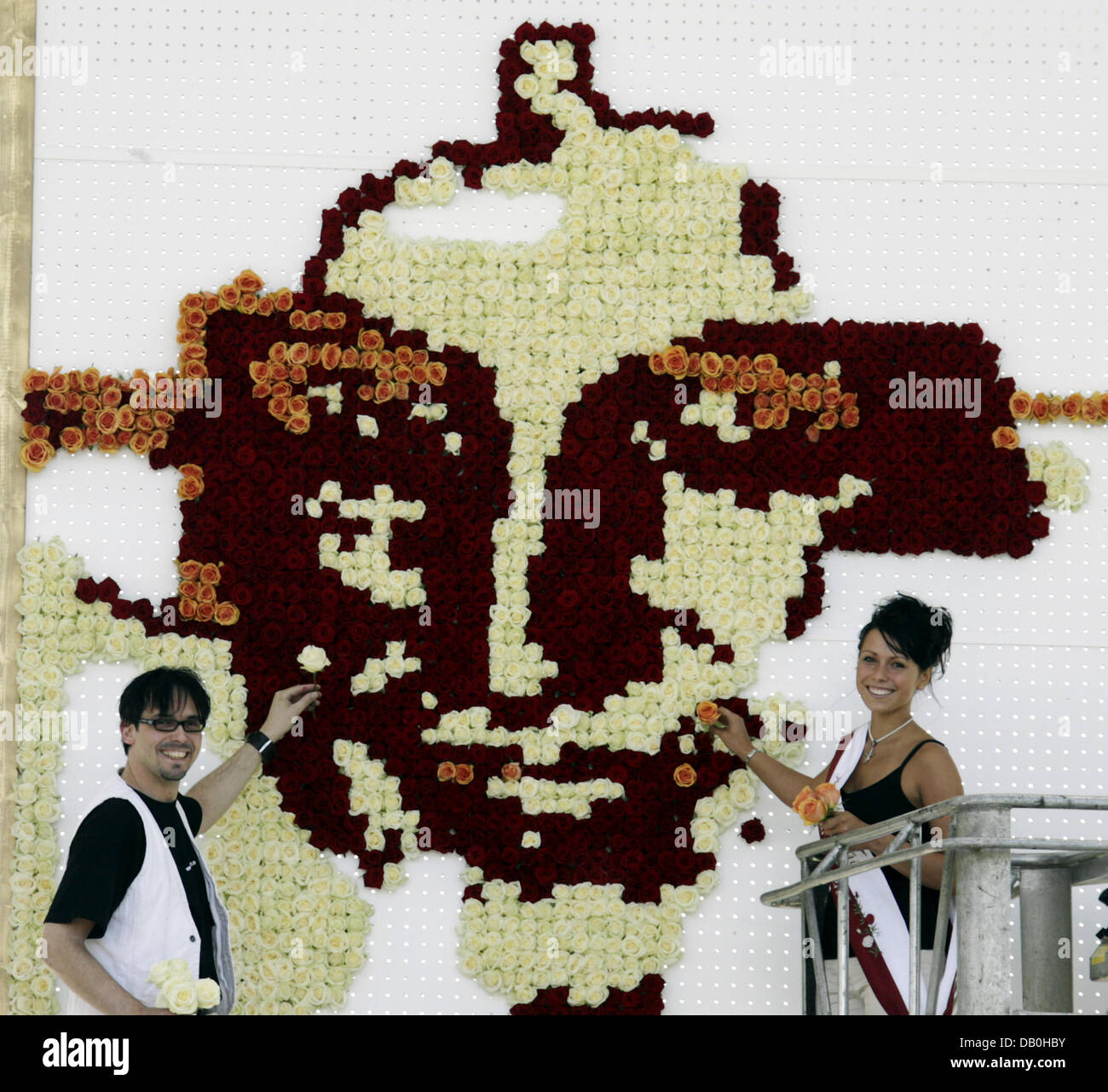German artist Frank Reich and rose queen Juliane Rausch (R) assemble a ...