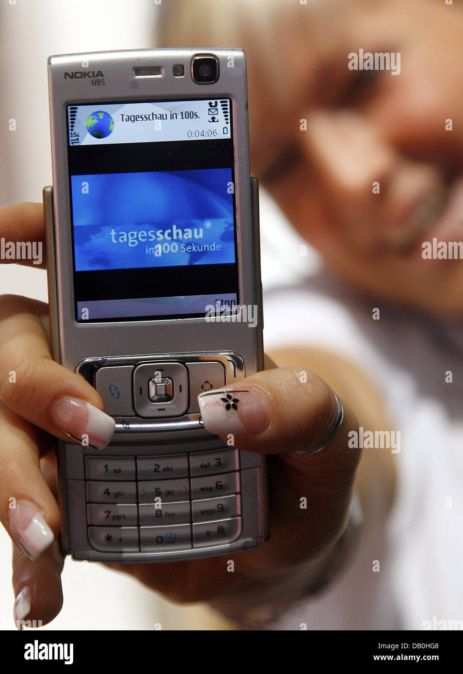 A female host presents a television-ready mobile phone at the stand of ...