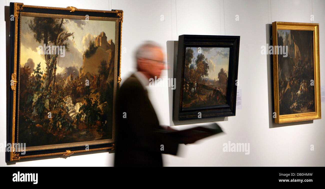 A visitor to the Nicolaes Berchem exhibition passes paintings of ...