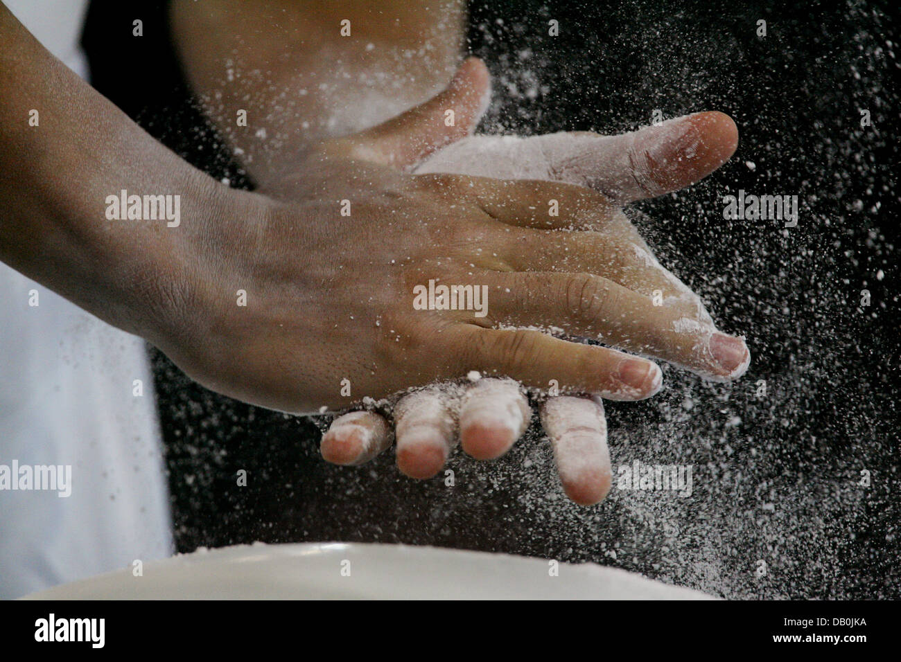 A British athlete chalks his hands prior to the pommel horse exercise ...