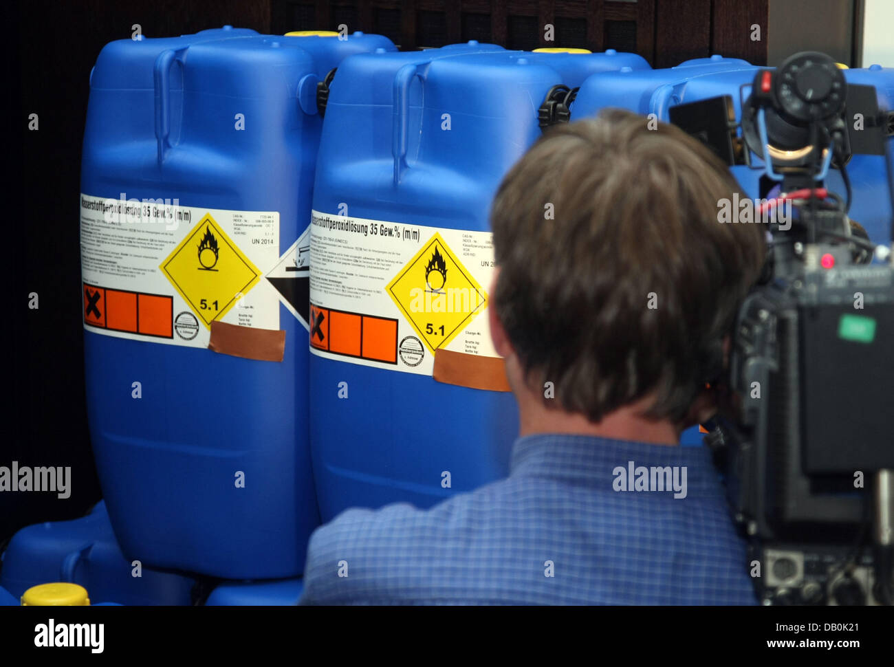 A cameraman films empty barrels of hydrogen peroxide dilution in the ...