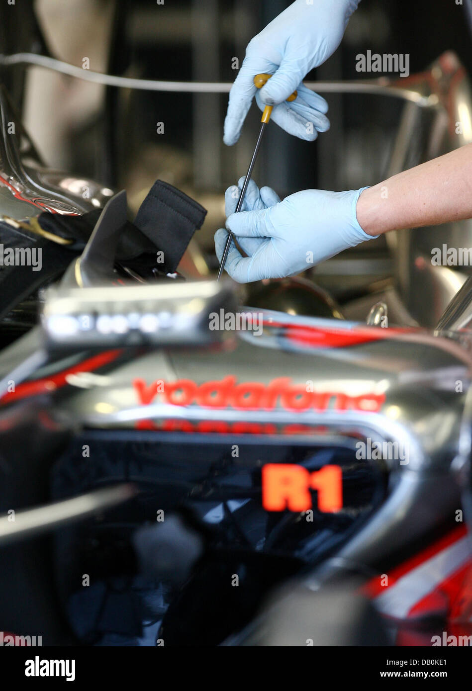 A mechanic of McLaren Mercedes works at the motor of Fernando Alonso's ...