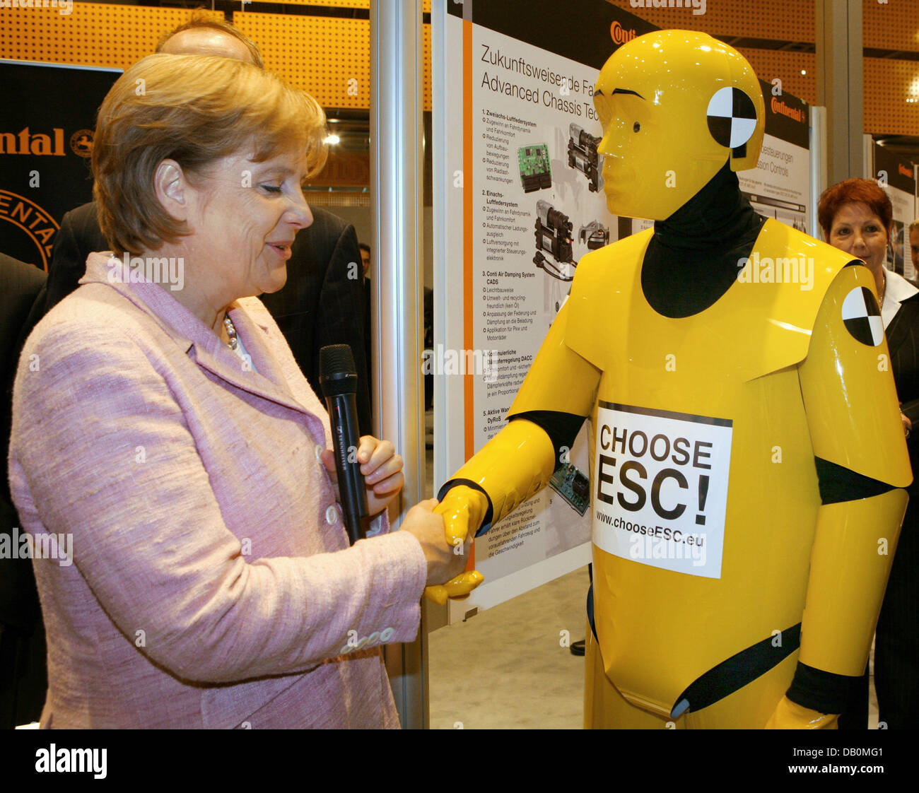 German Chancellor Angela Merkel (L) shakes hands with a yellow dummy at ...