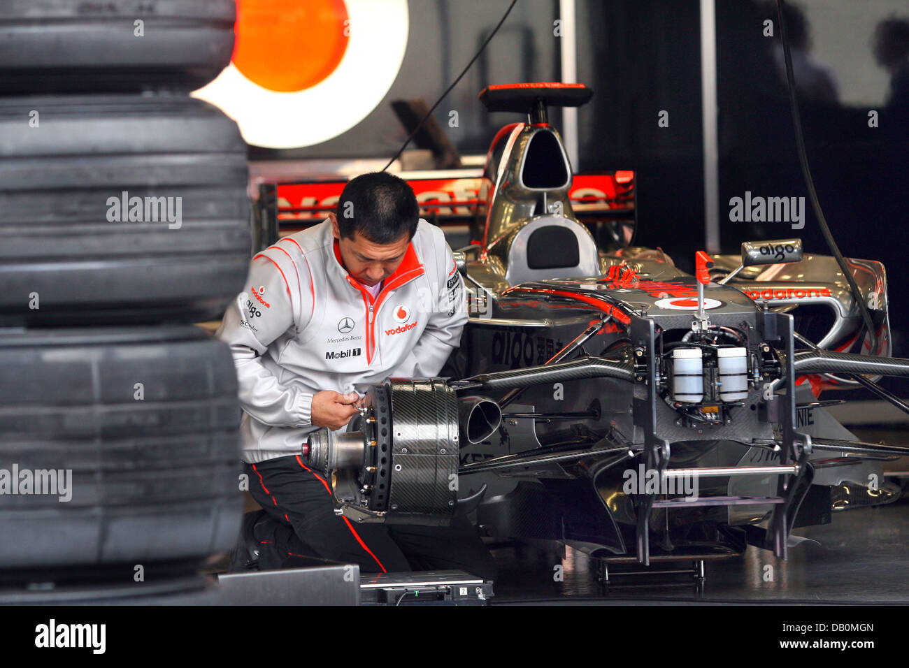 A mechanic of McLaren Mercedes checks the race car in front of the pits ...