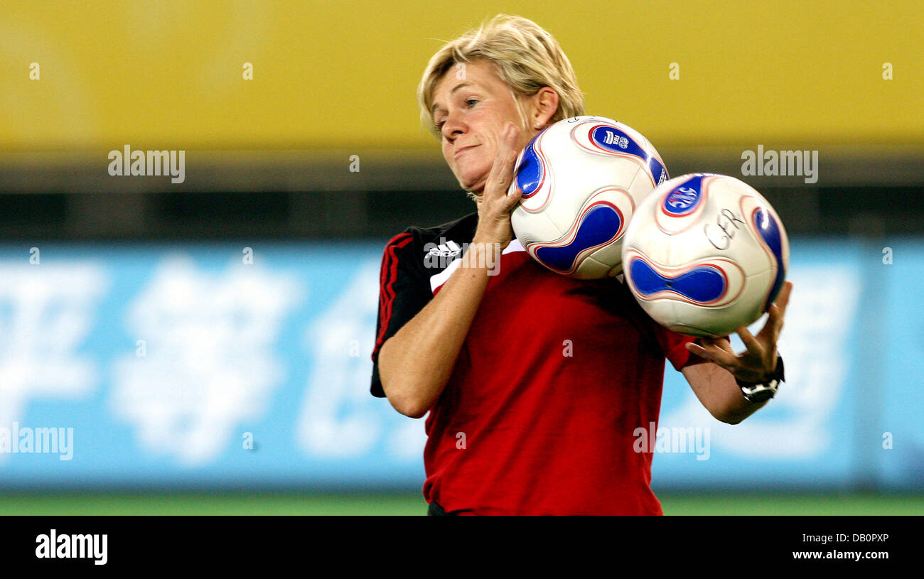 German national coach Silvia Neid carries balls during the training at ...