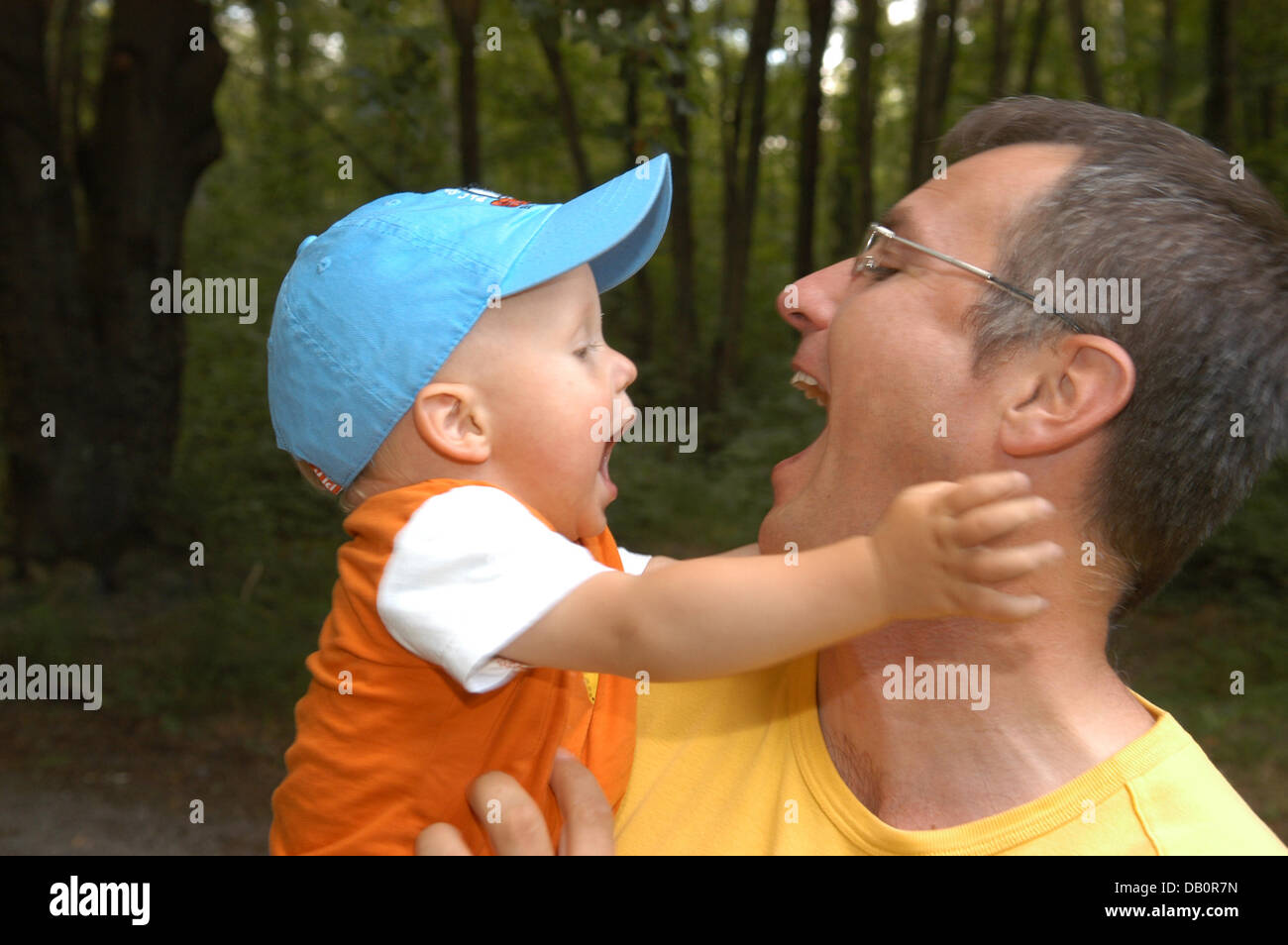 Father Peter Ott carries his son Lukas Ott on his arms and plays with ...