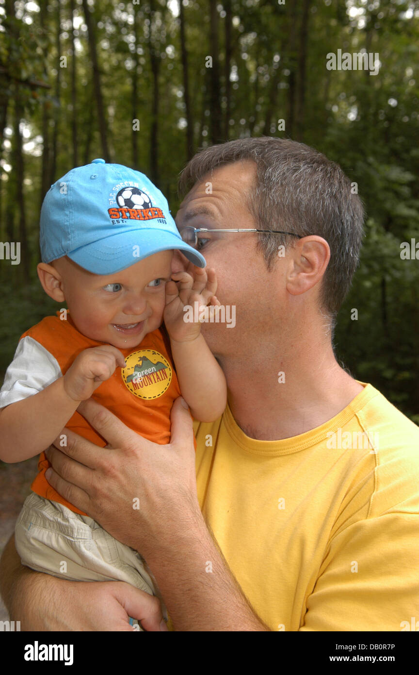 Father Peter Ott carries his son Lukas Ott on his arms and plays with ...