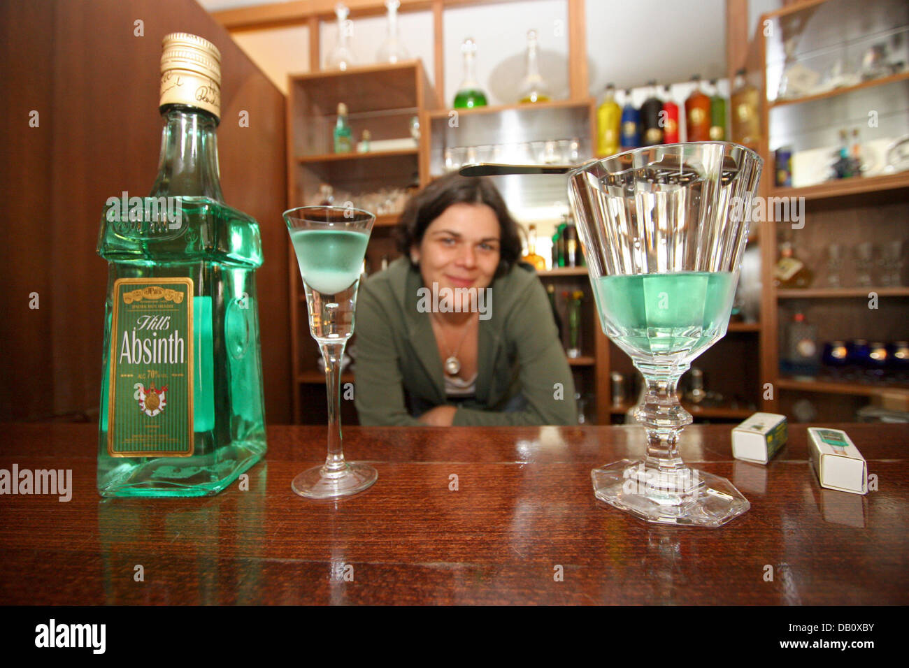 A women poses with a bottle of absinthe at the salesroom of Hill's ...