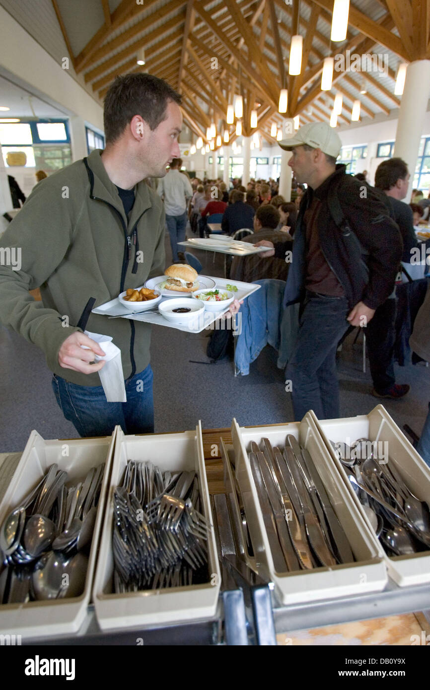 Students carry their food trays at the Haste university refectory of ...