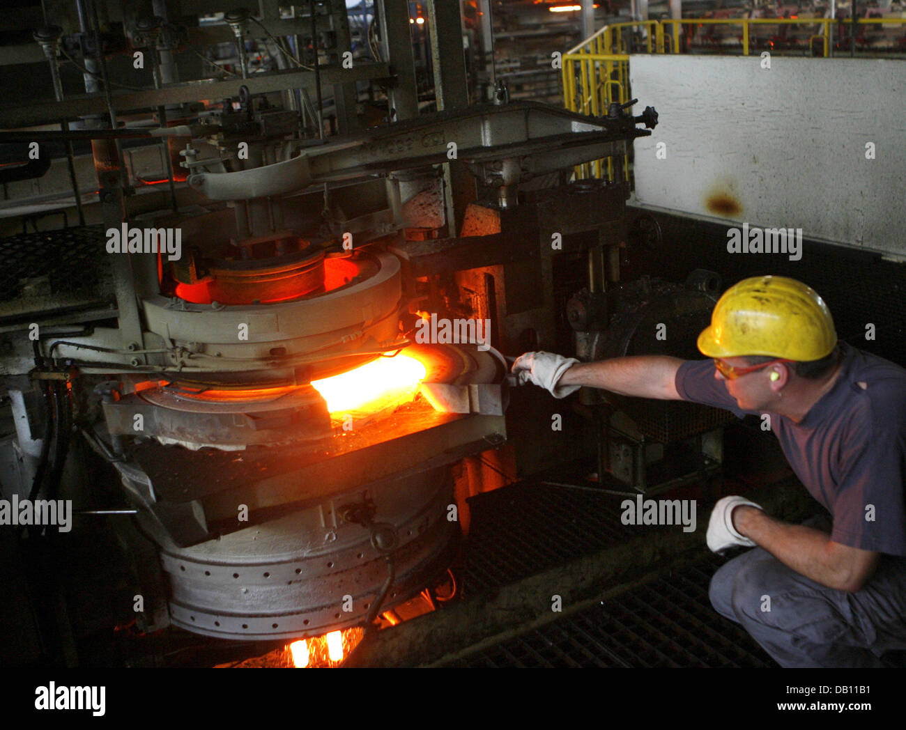A member of staff checks the production of glass bottles in a ...