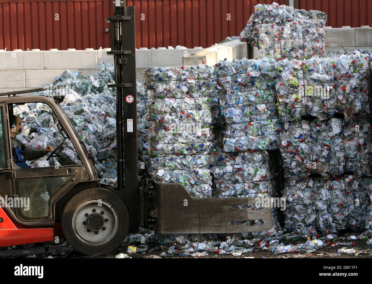 Bales of pressed deposit bottles are carried by a fork lifter in a ...