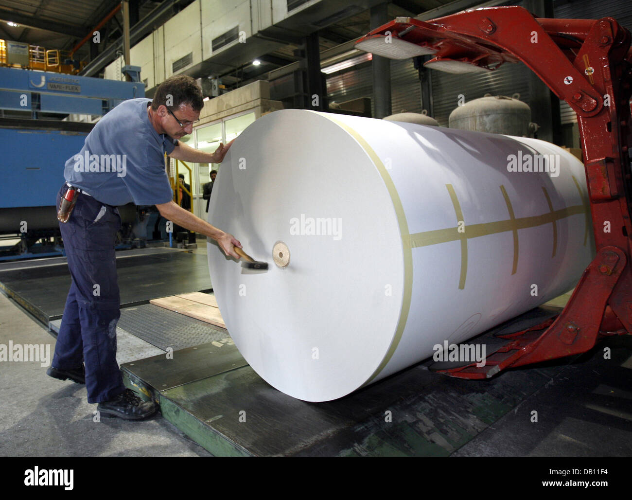 A paper reel is prepared by an employee in a paper factory in Kreuzau ...