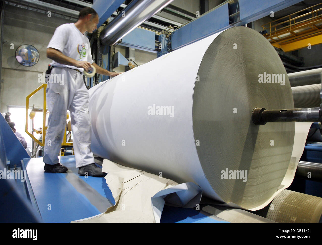 A worker prepares a paper roll for shipping at a paper factory in ...