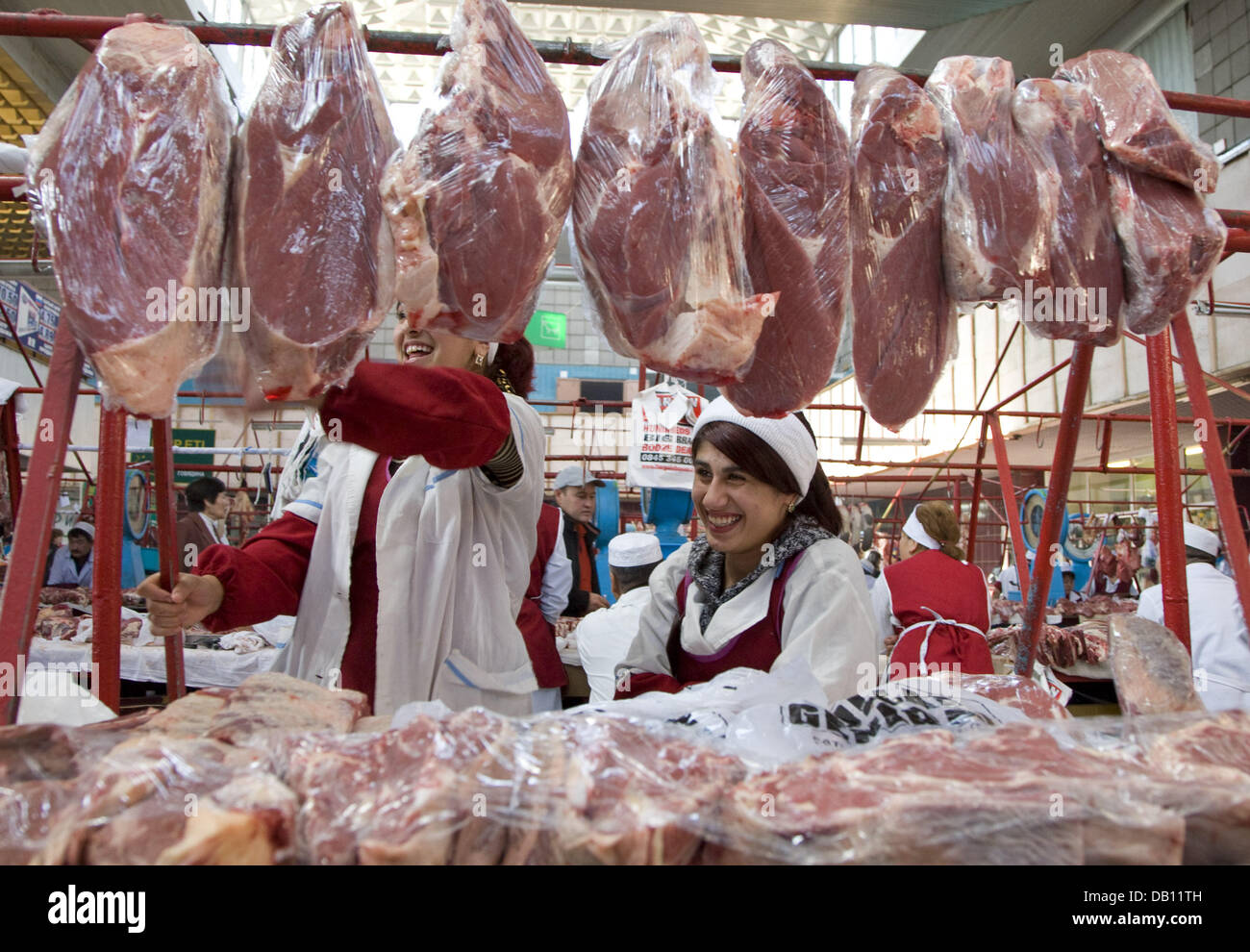 Meat vendors smile behind their stall at a market hall in Almaty ...