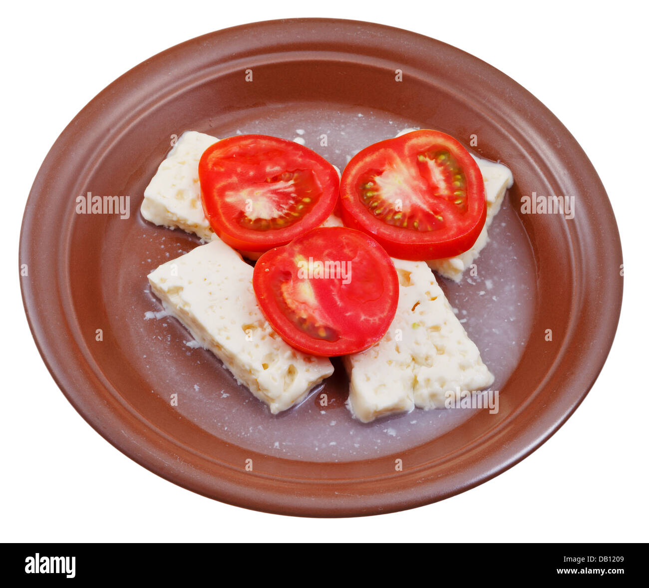 fresh sliced tomatoes and brined cheese on plate isolated on white ...