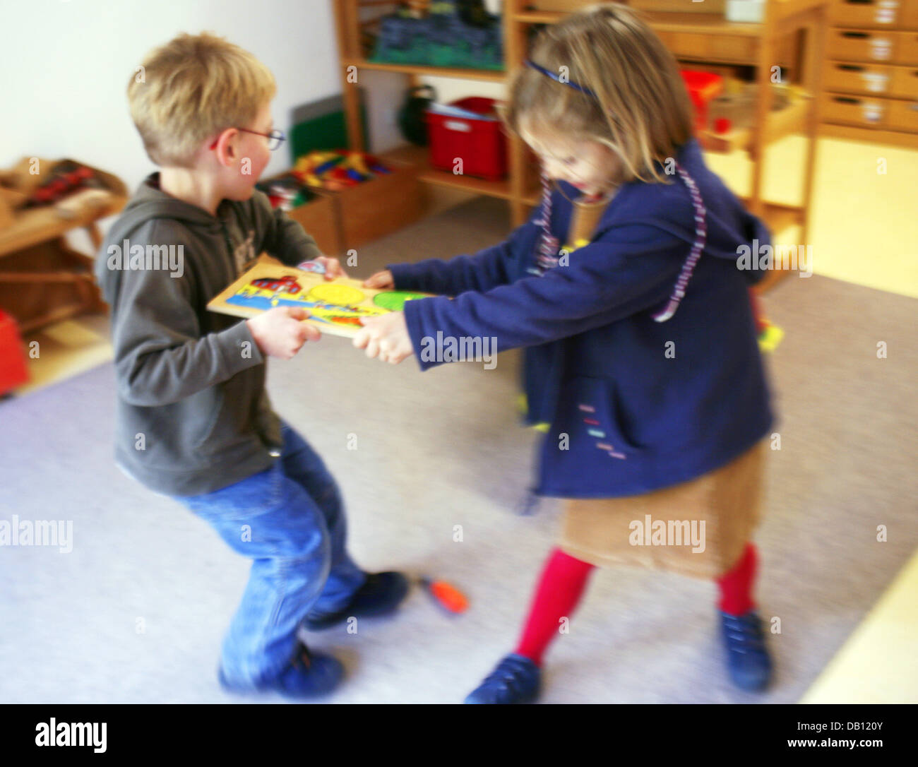 A 4-year-old boy and a same-aged girl fight about a toy in a ...