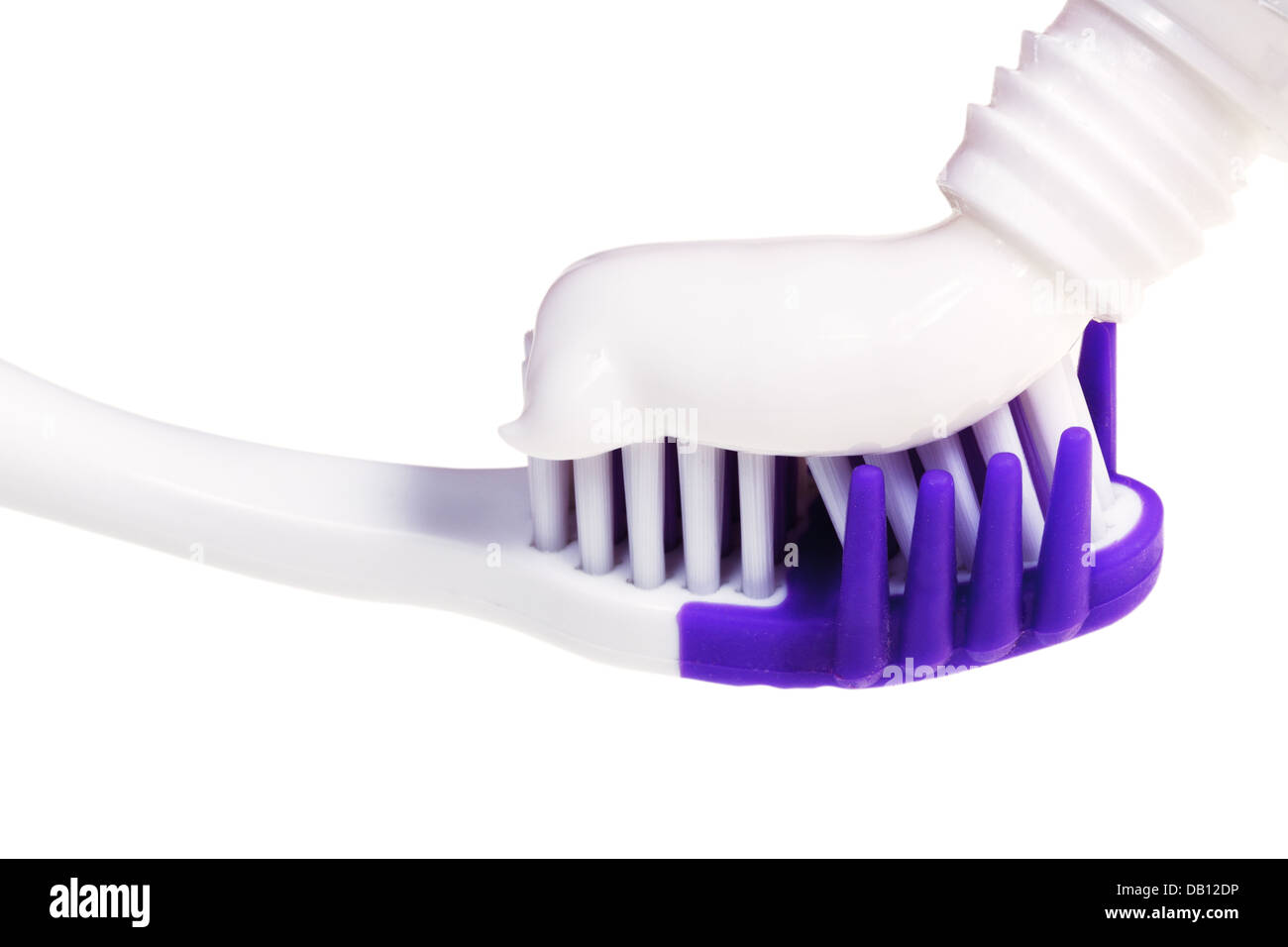 extruded tooth paste from tube on modern toothbrush close up isolated ...