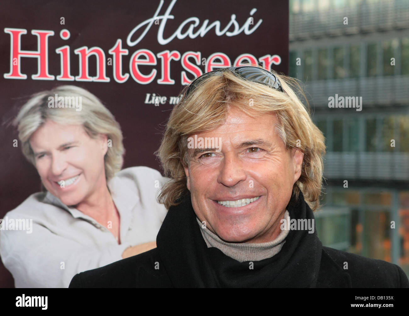 Austrian folk music star Hansi Hinterseer poses in front of a poster of ...