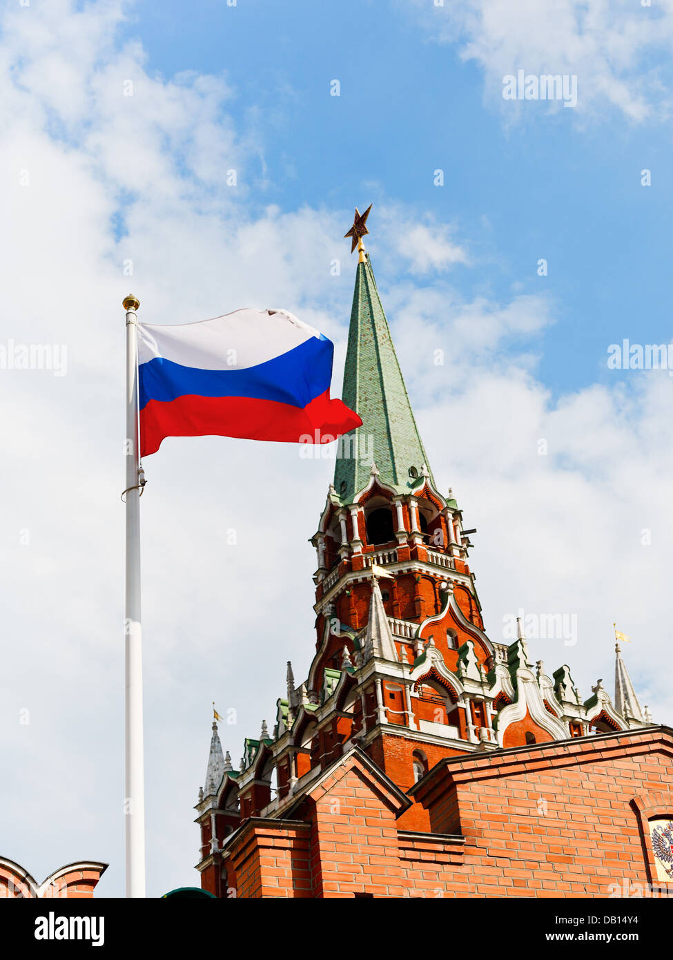 Russian state flag fluttering in wind with Kremlin Troitskaya tower on ...