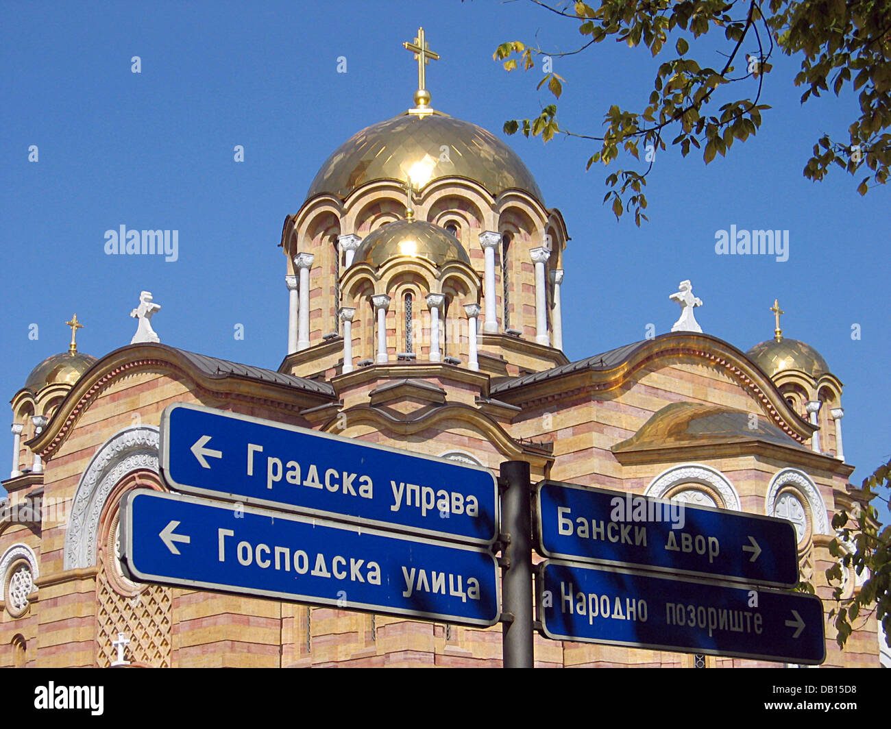 A signpost with cyrillic letters is pictured in front of an orthodox ...