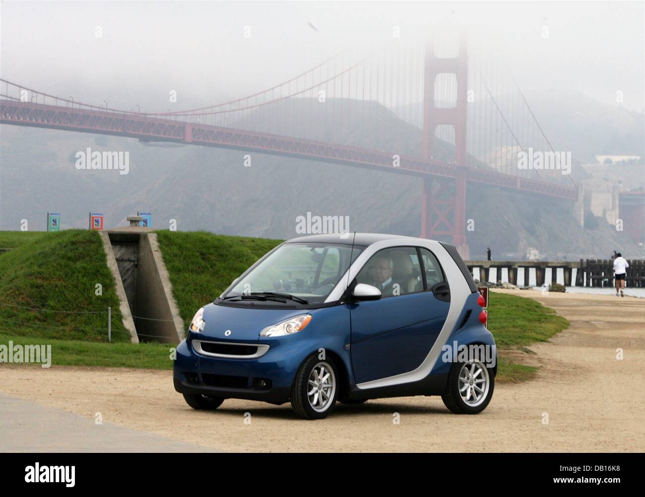 The picture shows a smart car with the Golden Gate Bridge in the ...