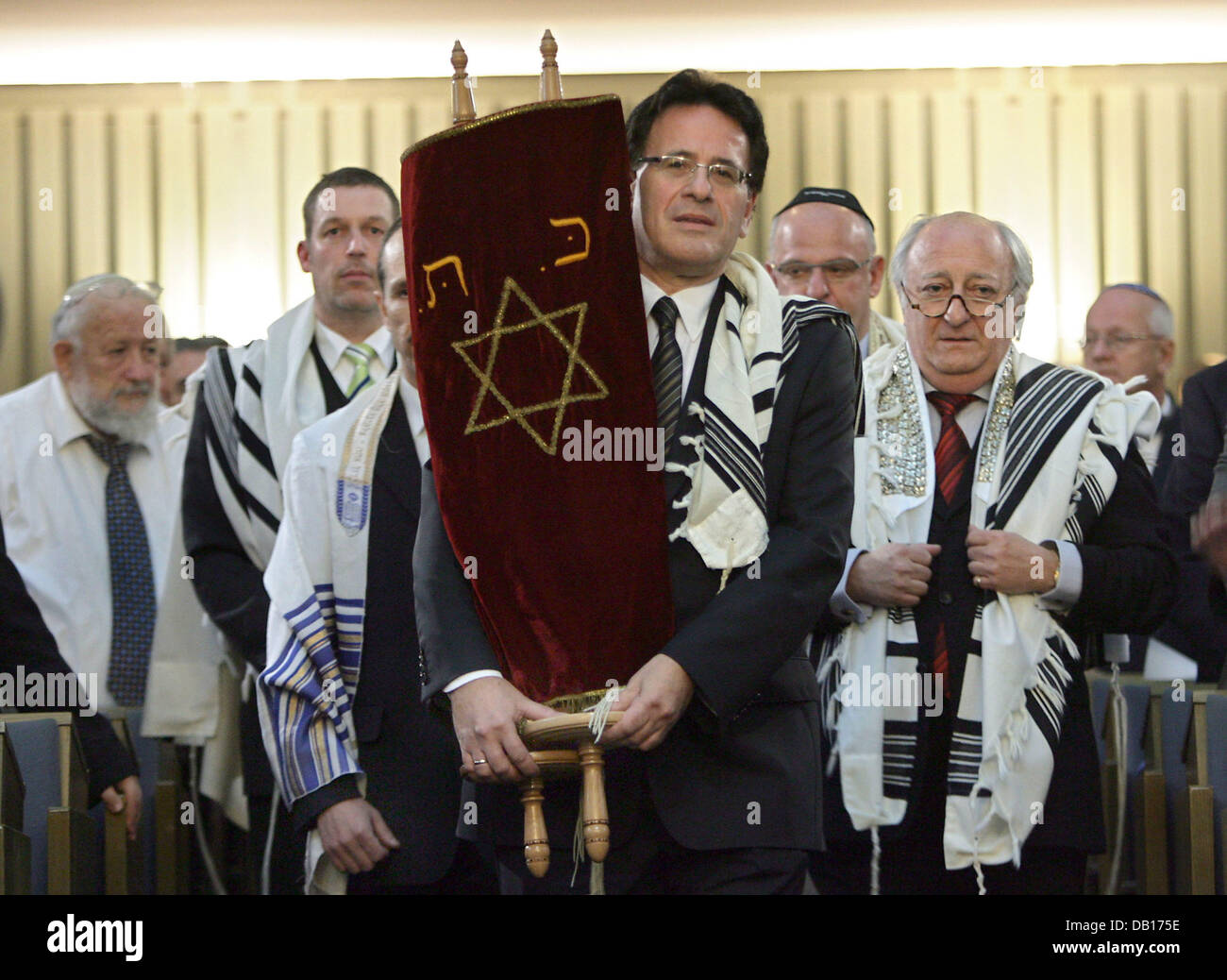 Jewish community members carry a Torah scroll into the synagogue in ...