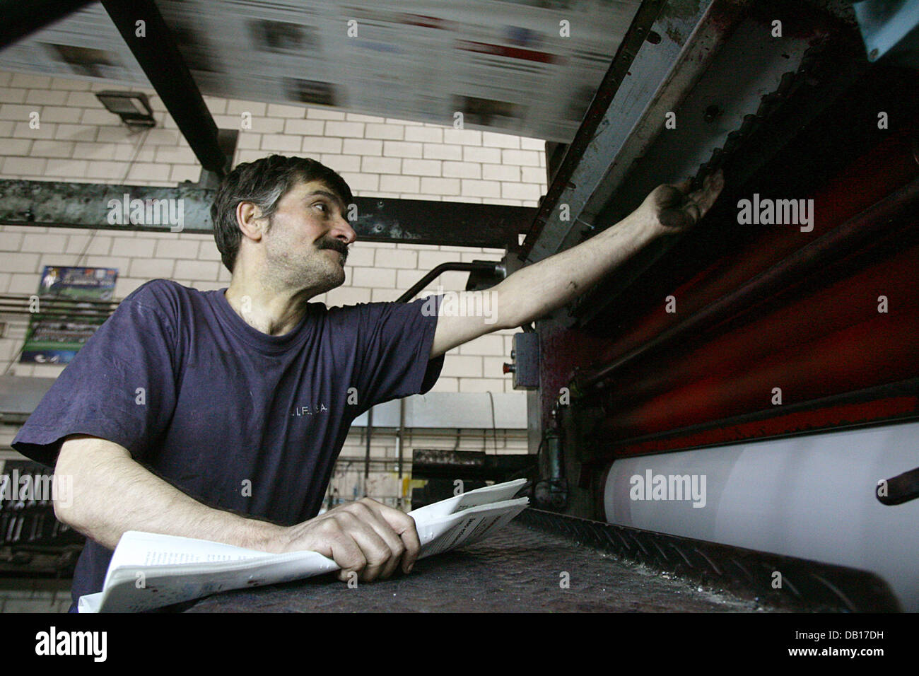 An employee sets the MAN-offset printing machine during the production ...
