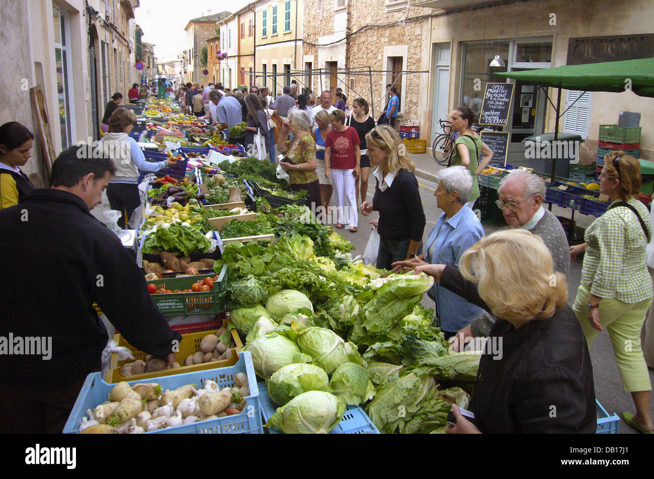 People bargain at the weekly market's booths on the popular tourist ...
