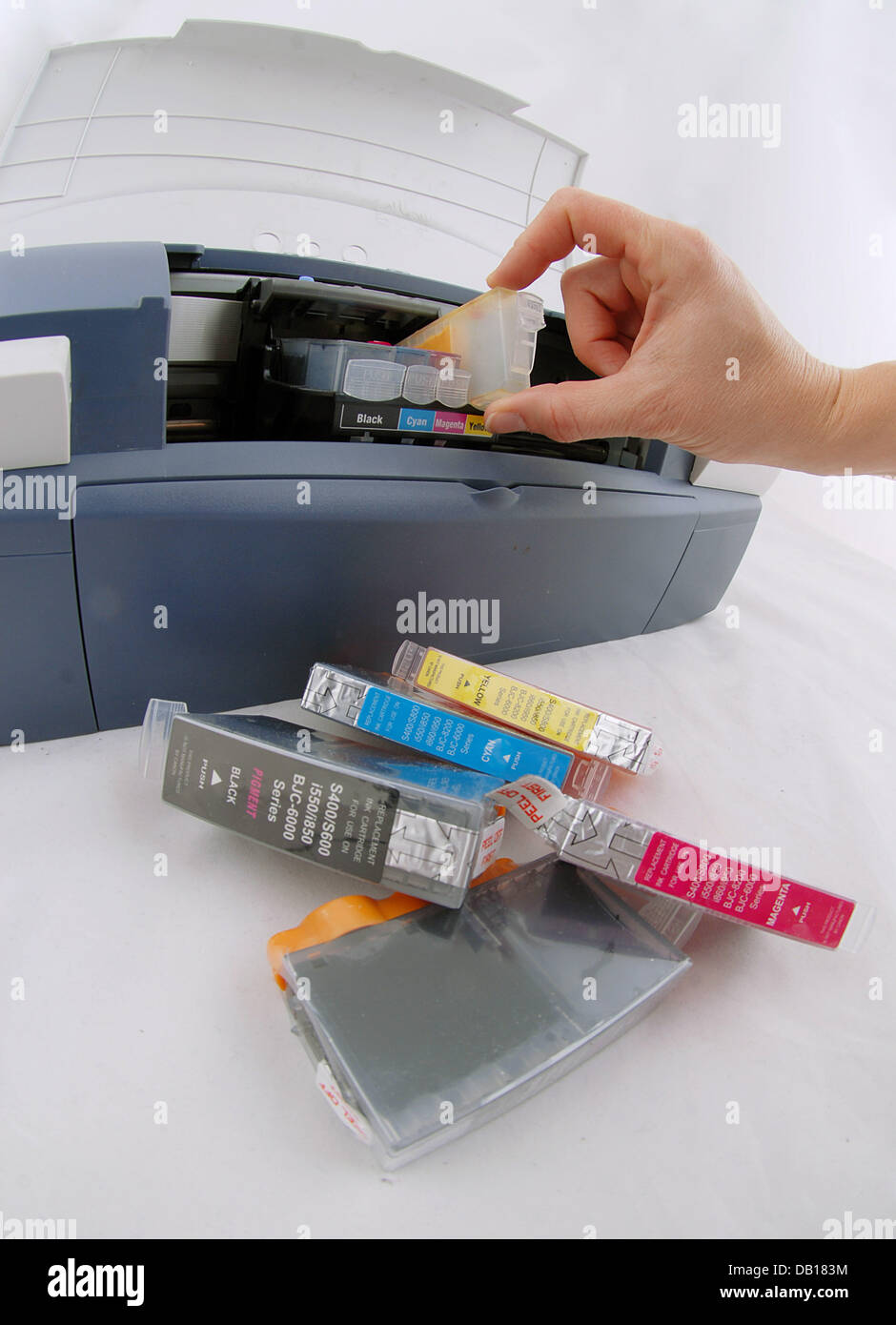 A person switches an inkjet printer's colour cartridges (cyan, magenta ...