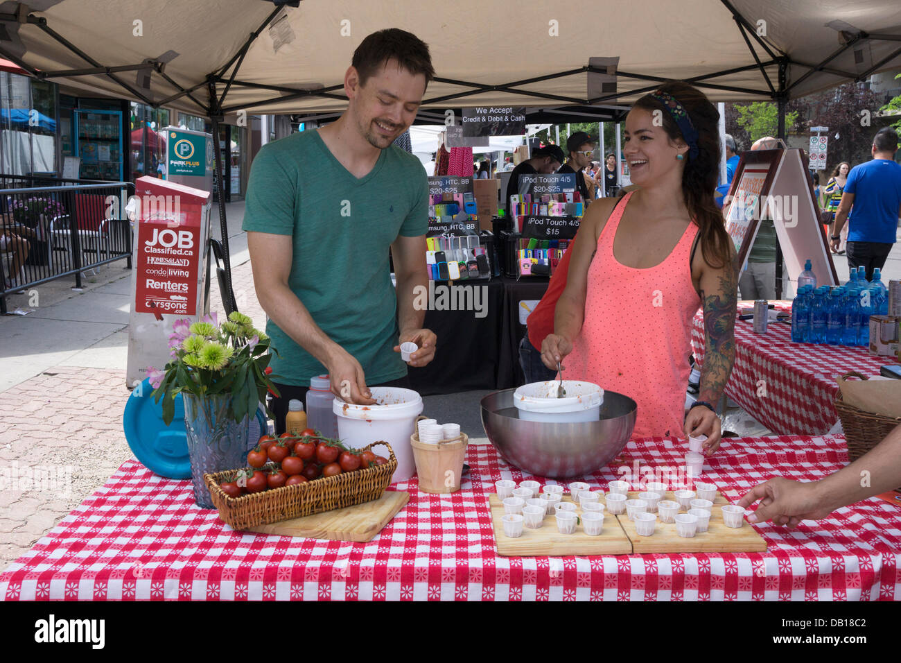 Cheerful man and woman spoon samples for the salsa tasting contest ...