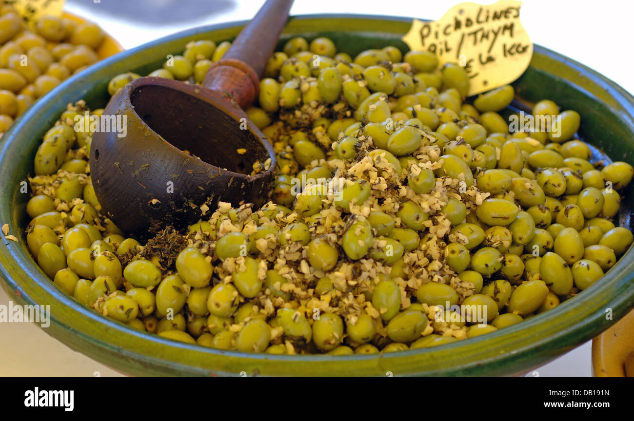 Green olives seasoned with garlic and thyme are on display at a local ...