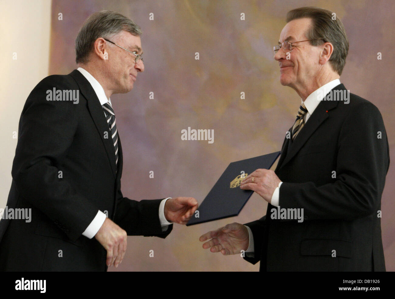 German President Horst Koehler (L) hands over the certificate of ...