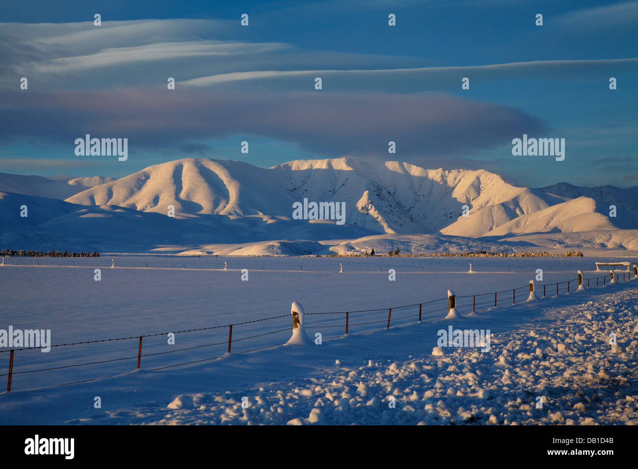Last light on snowy farmland and Hawkdun Range, Maniototo, Central Otago, South Island, New ...