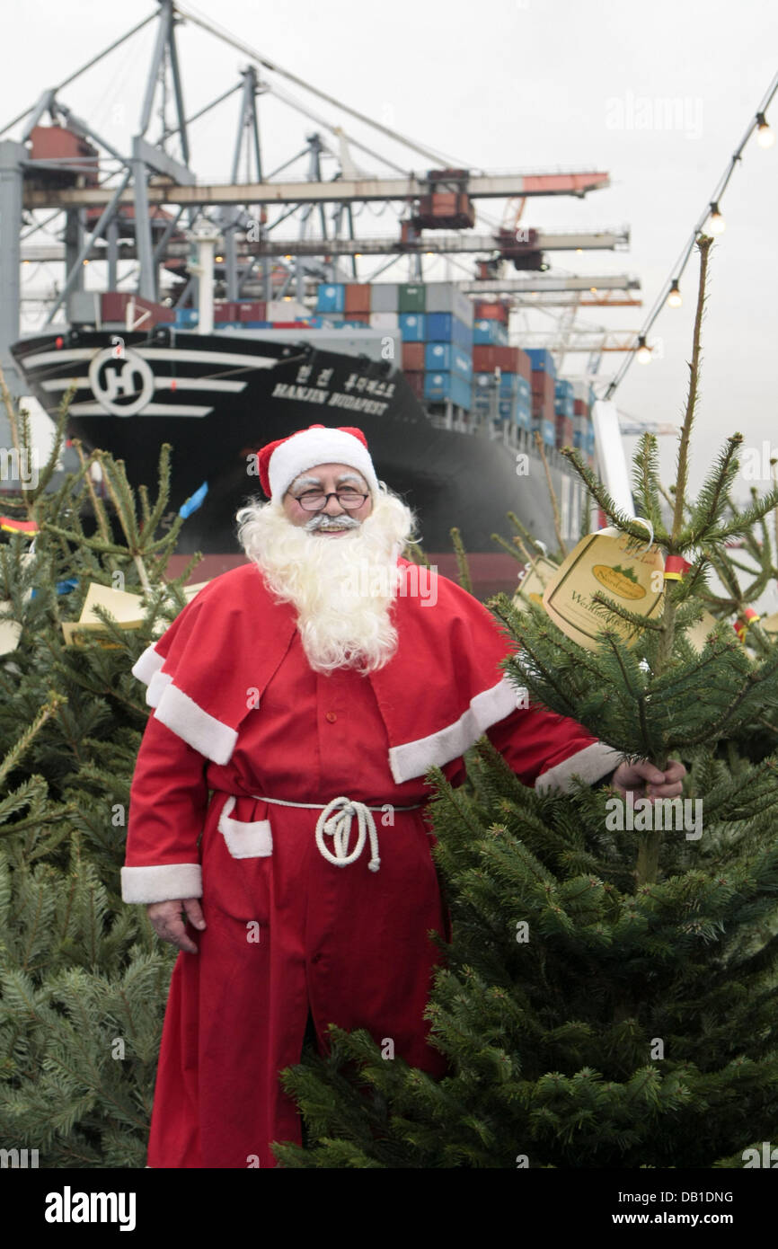 Santa Clause poses with Chrismas trees in front of container ship ...