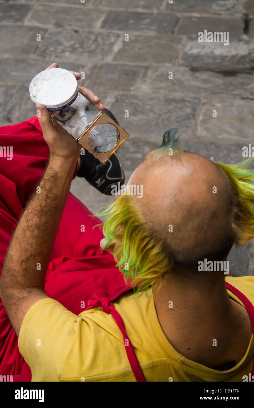 Clown adjusting his make-up and taking a break from entertaining ...