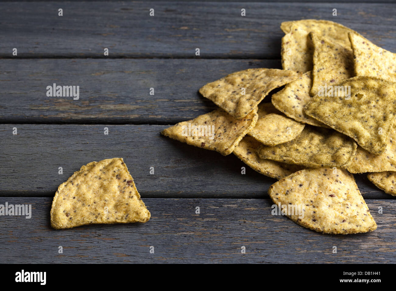 single corn chip next to a pile of chips Stock Photo - Alamy