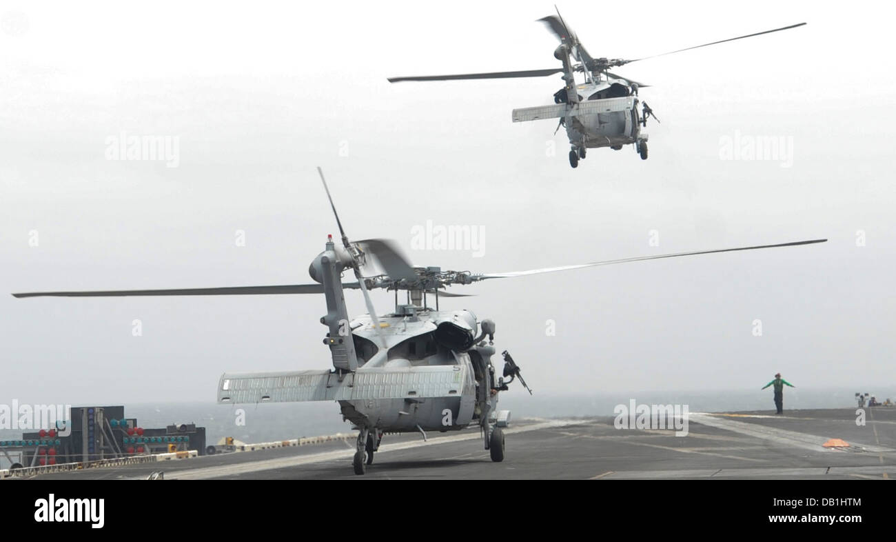 Two MH-60S Sea Hawk helicopters assigned to Helicopter Sea Combat Squadron (HSC) 6 lifts off of ...