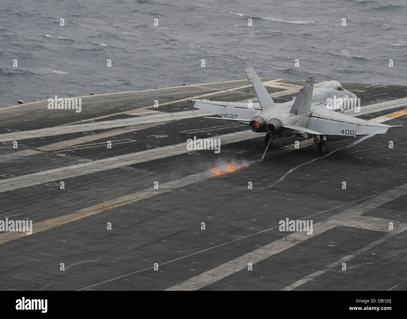 Sparks fly from the tail hook of an F/A-18C Hornet assigned to the ...