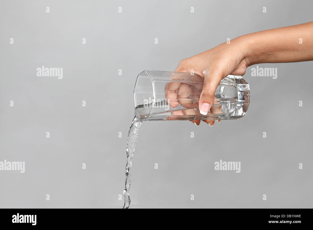 Woman pouring water from transparent glass Stock Photo - Alamy