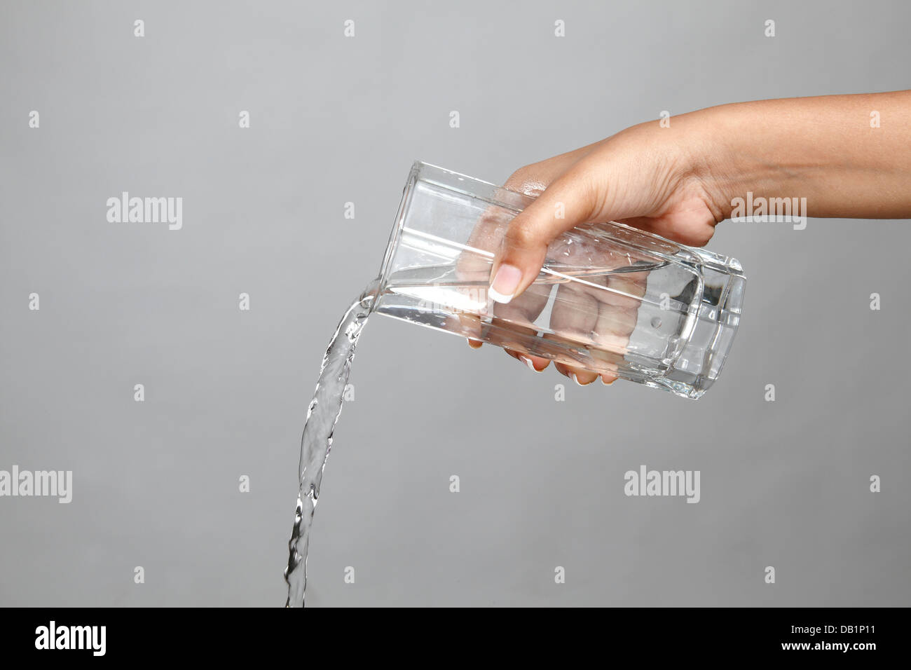 Woman pouring water from transparent glass Stock Photo - Alamy