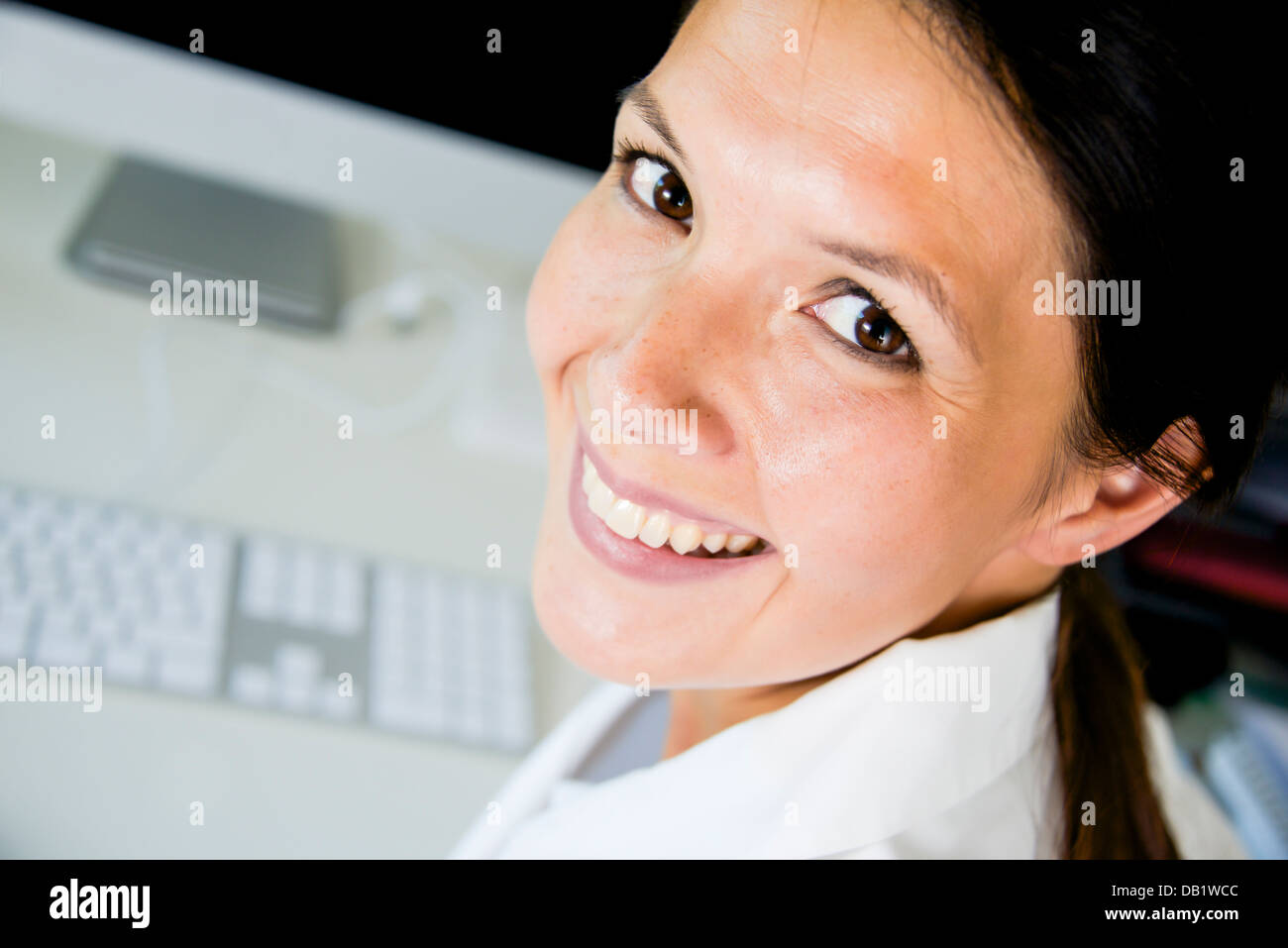 woman sitting at working desk is smiling Stock Photo - Alamy